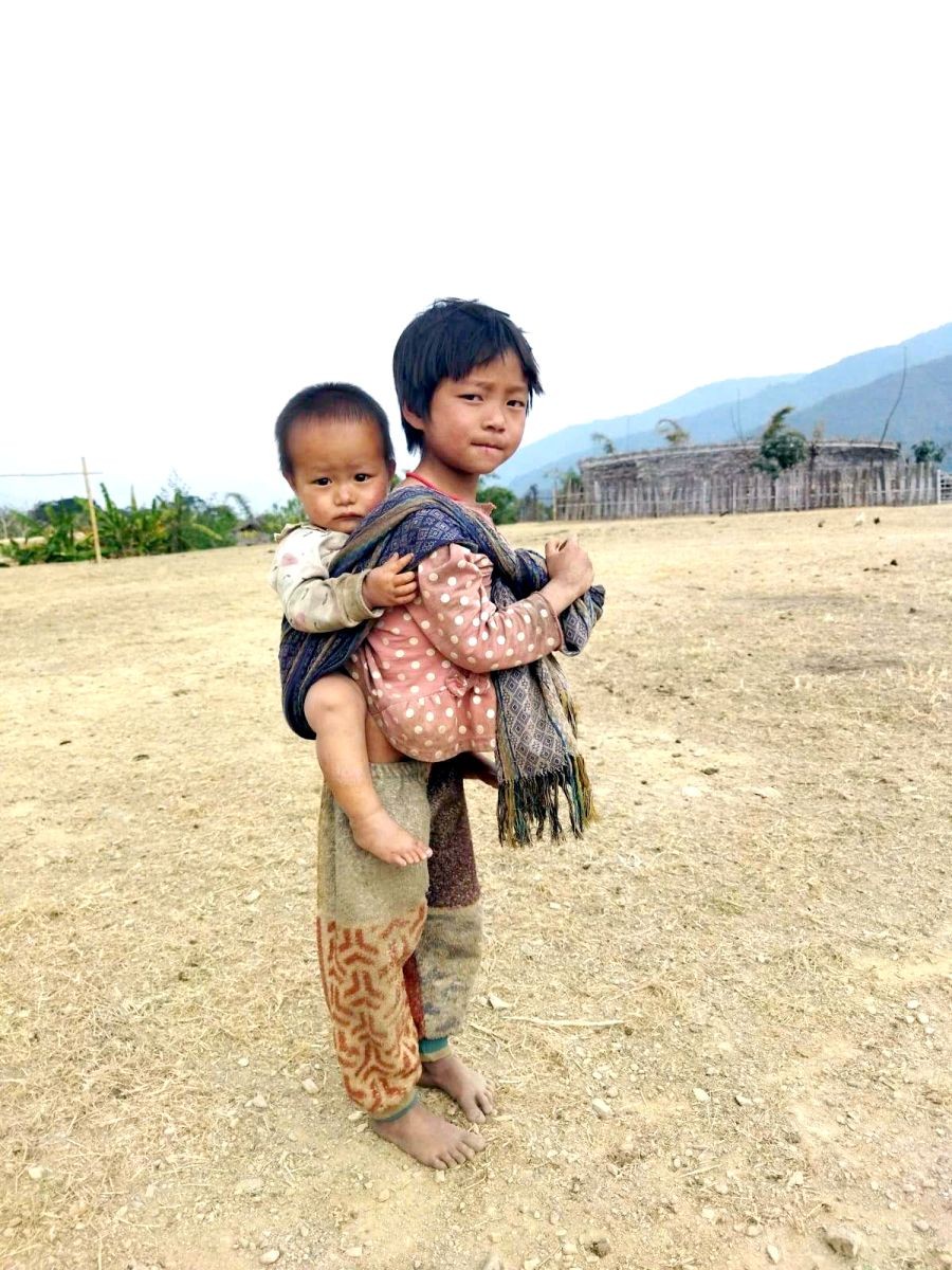 A young girl carries a child on her back at Naga village of Solo/Chiu ...